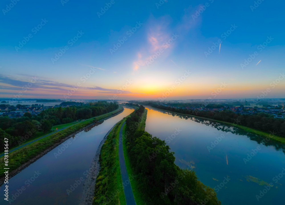 Capture the serene beauty of dawn as the sun peeks under a steel-blue ...
