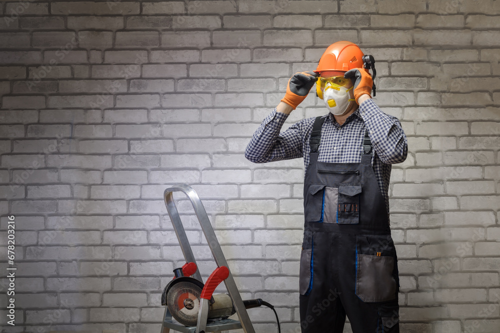 Builder putting on personal protective equipment. Portrait of male ...