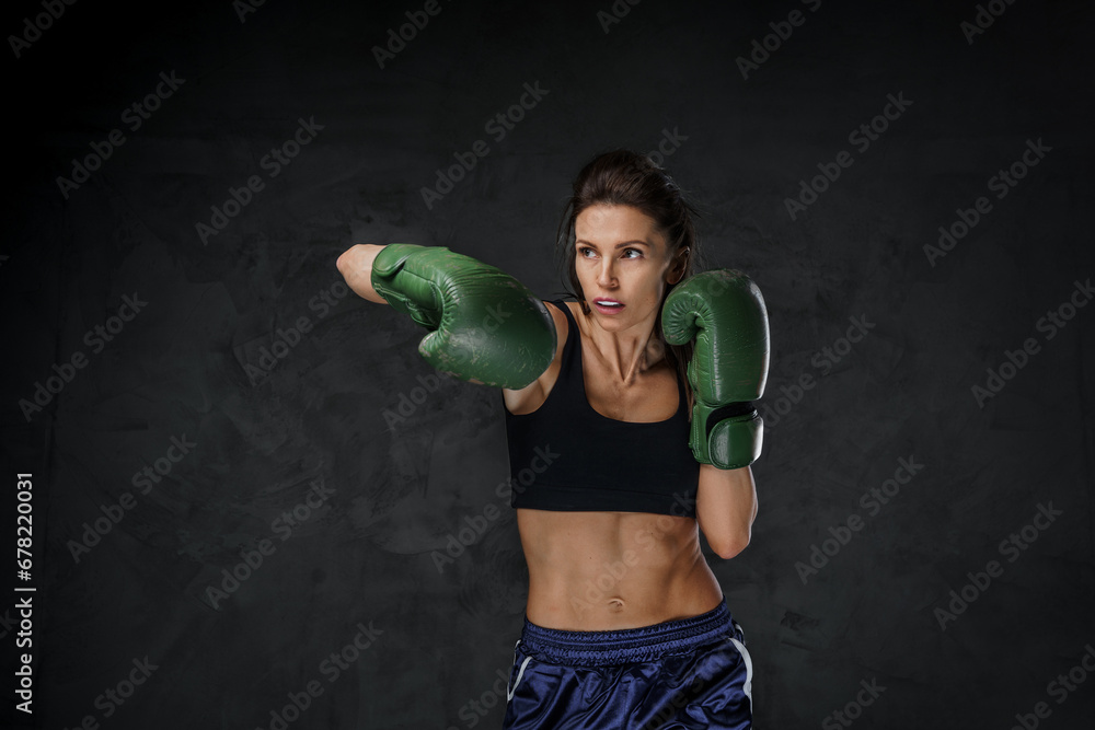 Athletic female fighter in sports bra, shorts, and boxing gloves ...