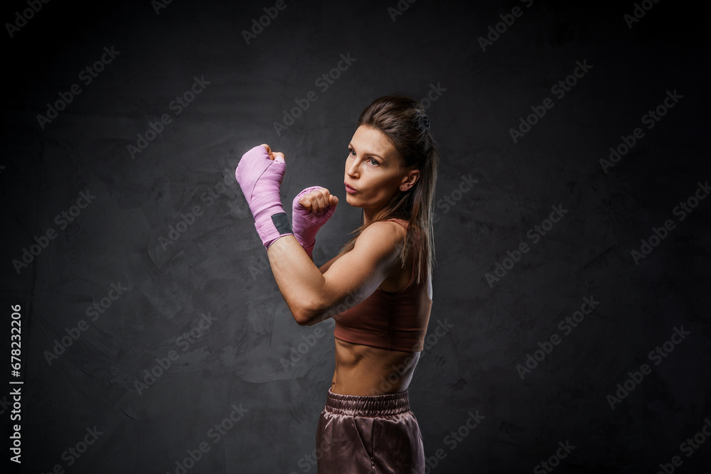 Muscular woman boxer demonstrating striking skills, dressed in sports ...