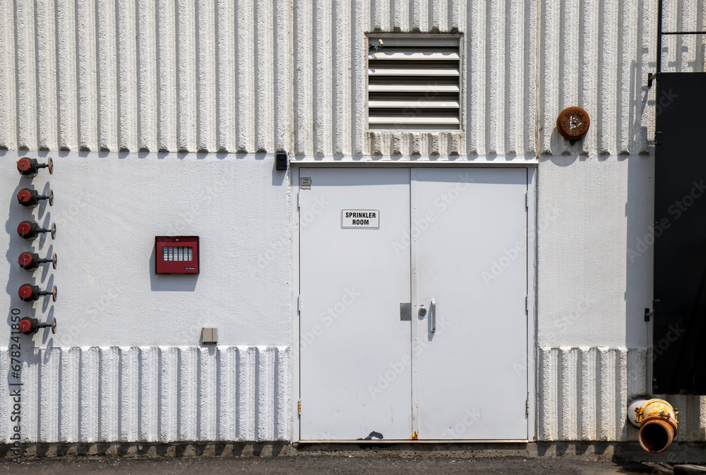 Exterior white steel doors leading to a building sprinkler room ...