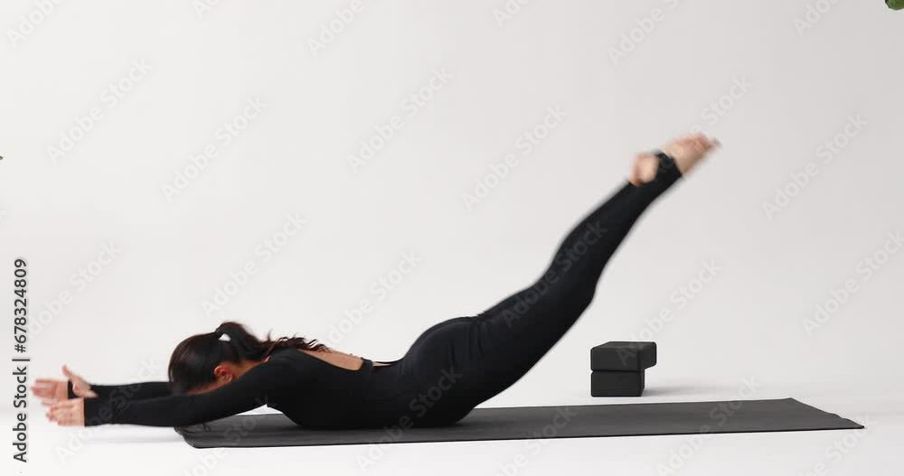 A brunette woman practicing yoga, performs the Makarasana exercise ...