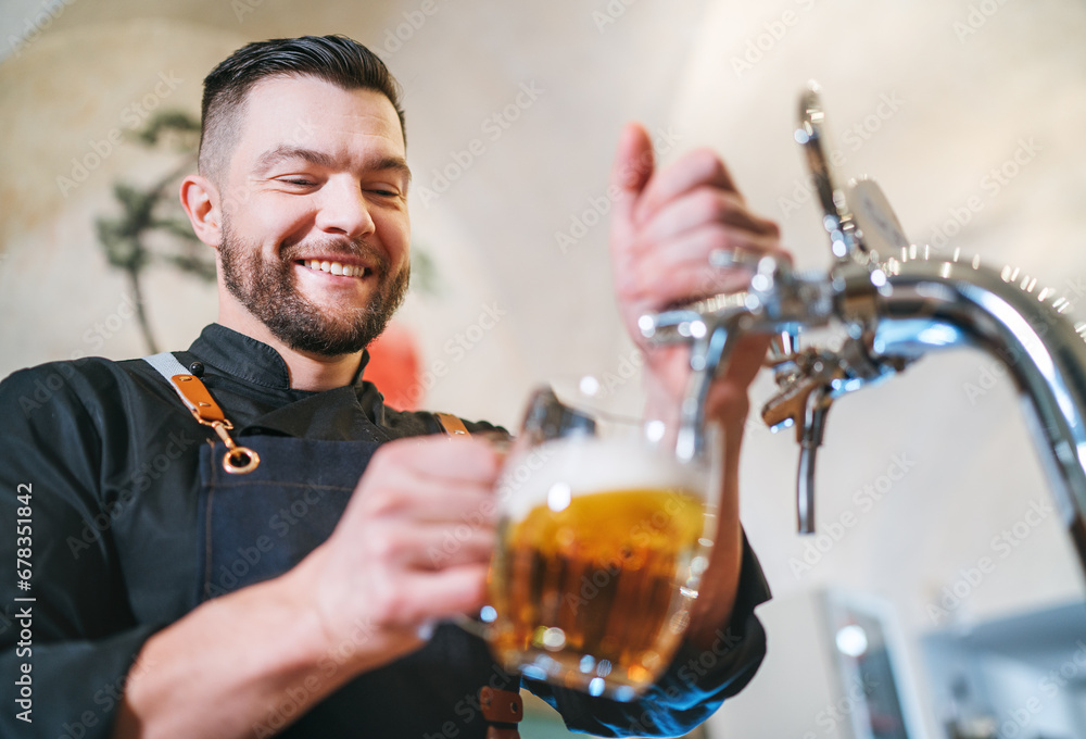 Smiling stylish bearded barman dressed black uniform with an apron ...