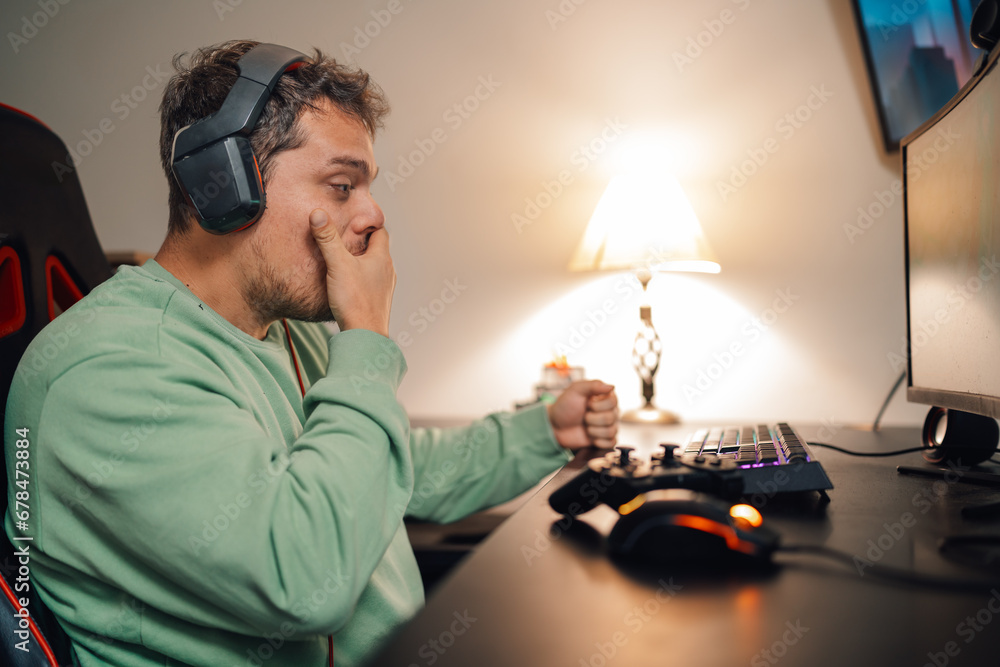 Desperate gamer covering his mouth while playing console Stock Photo ...