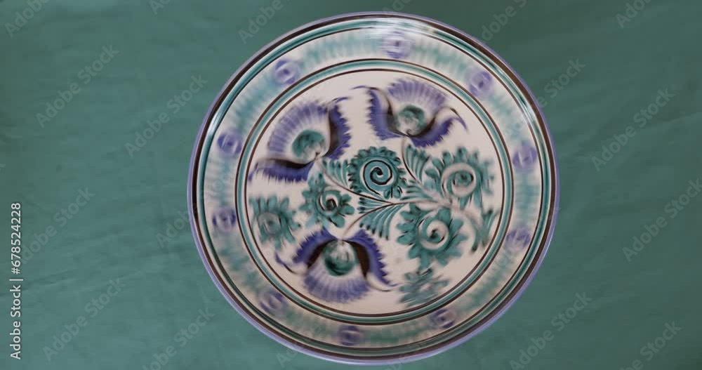 Rotation of a finished porcelain plate painted with patterns in the ...