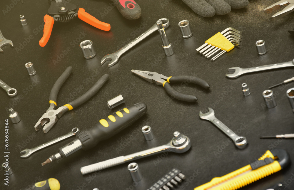 Handyman tool kit on black wooden table. Many wrenches and screwdrivers ...