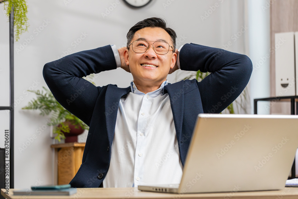 Asian mature businessman freelancer taking break leaning on chair after ...