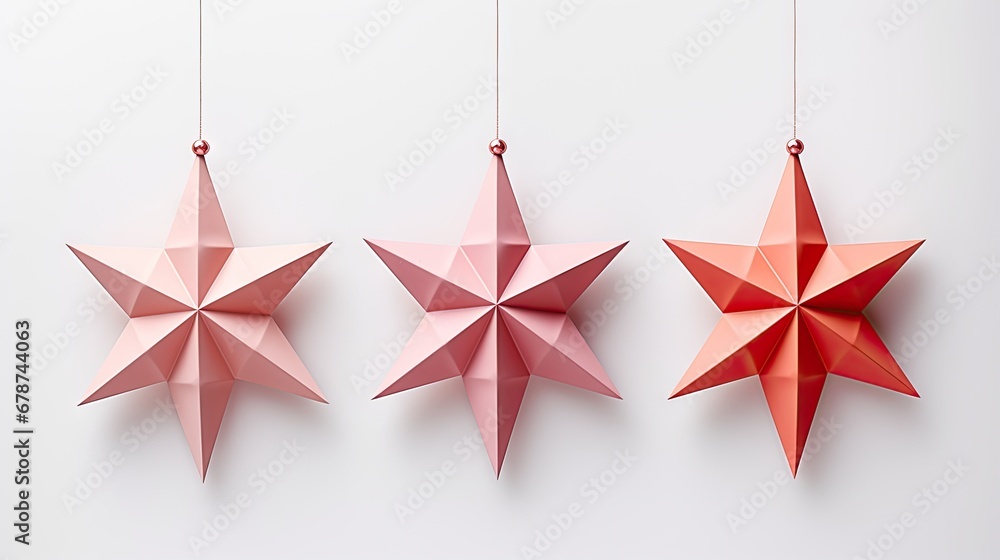 three pink origami stars hanging from strings on a white wall with a ...