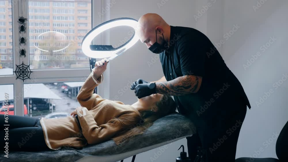 The girl looks in the mirror at her enlarged lips. The injection doctor ...