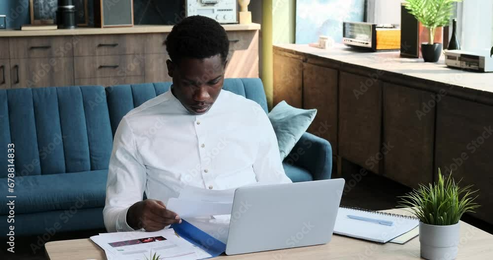An organized African American man manages tasks from home, juggling ...