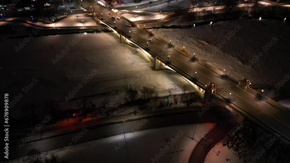 Drone footage of a winter night of cars driving on an illuminated ...