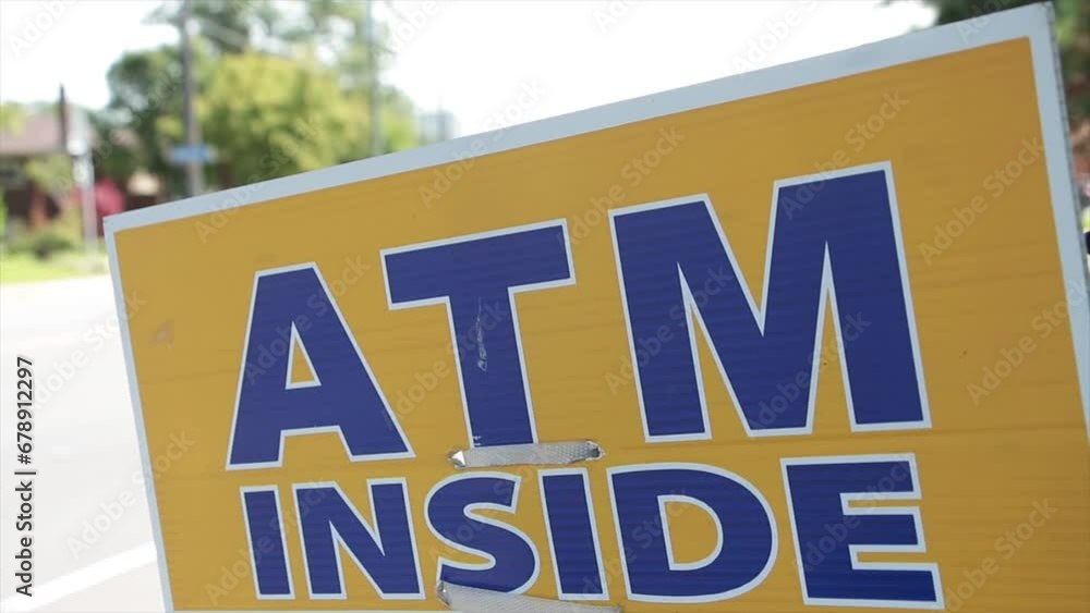 atm inside sign in black writing on yellow background with bright ...