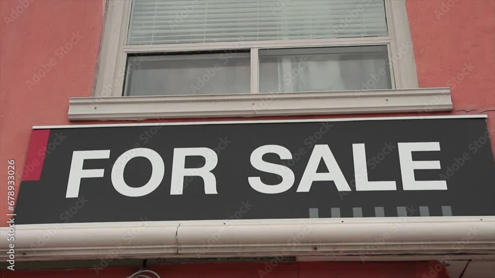 for sale sign beneath window on front of store, white capital letters ...