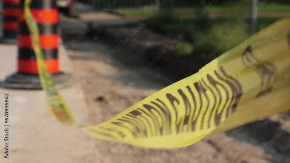 yellow and black caution tape blowing in wind tied to orange and black ...
