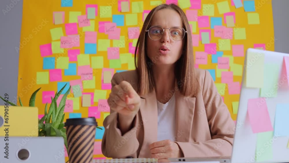 Angry woman boss wearing beige jacket and working on computer against ...