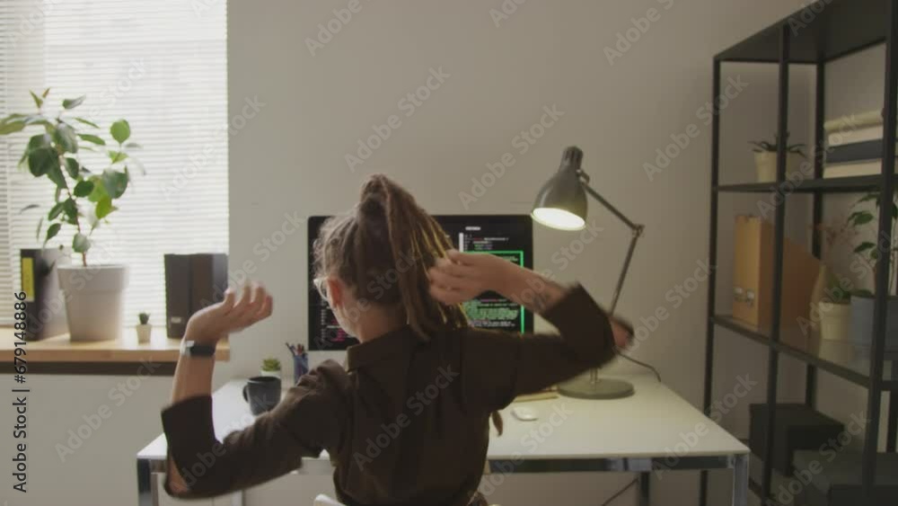 Back view waist up shot of Caucasian female programmer with dreadlocks ...