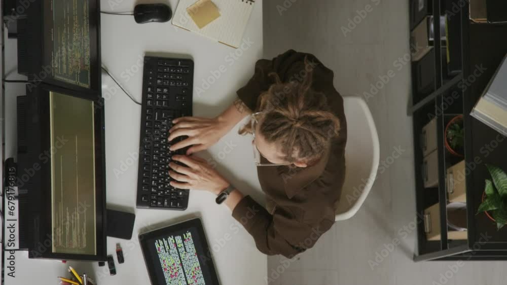 Top view of Caucasian female programmer with dreadlocks putting on eyeglasses and stretching her ...