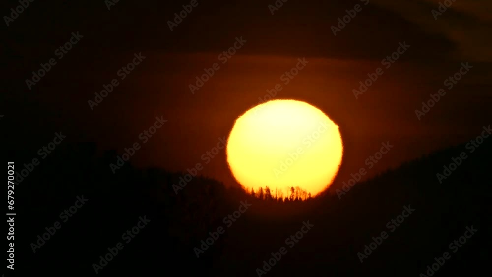 Dark sky and yellow sun during sunrise over horizon of mountains with ...