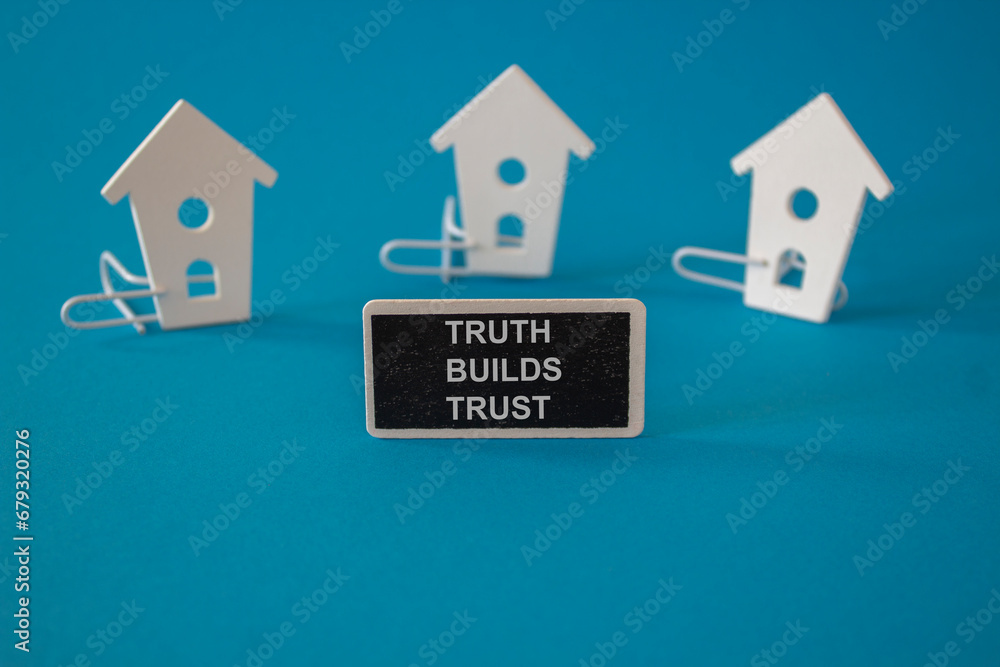 Truth builds trust symbol. Wooden houses sits next to a wooden black ...