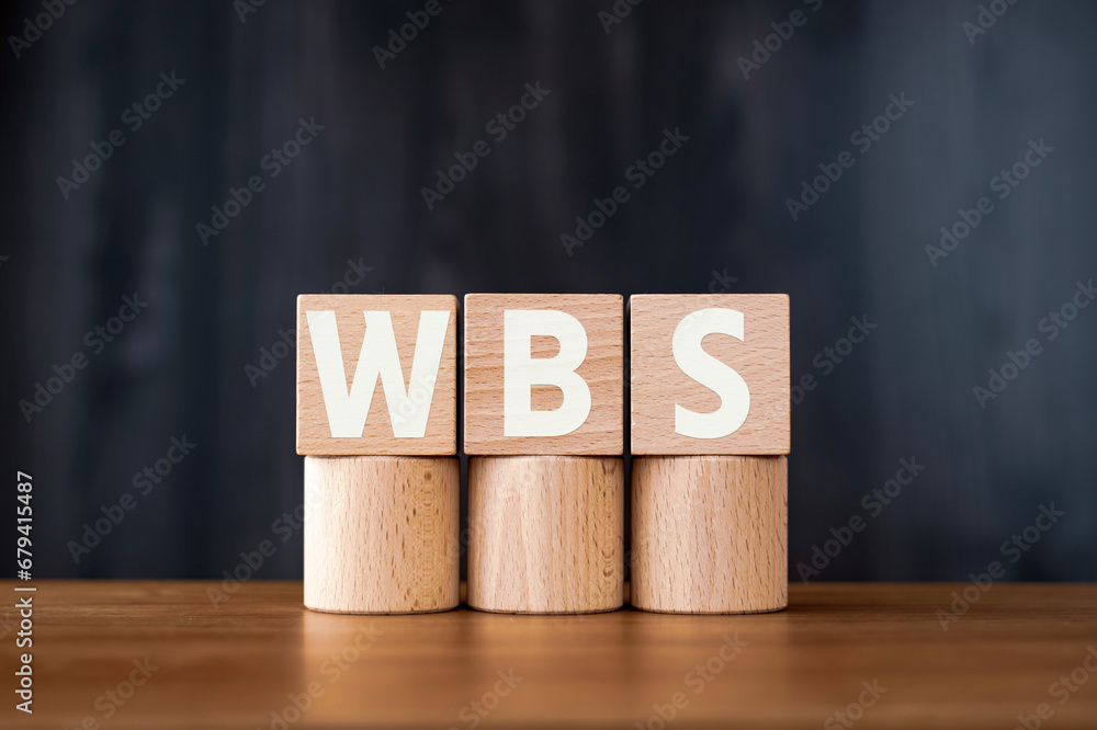 There is wood cube with the word WBS. It is an abbreviation for Work ...