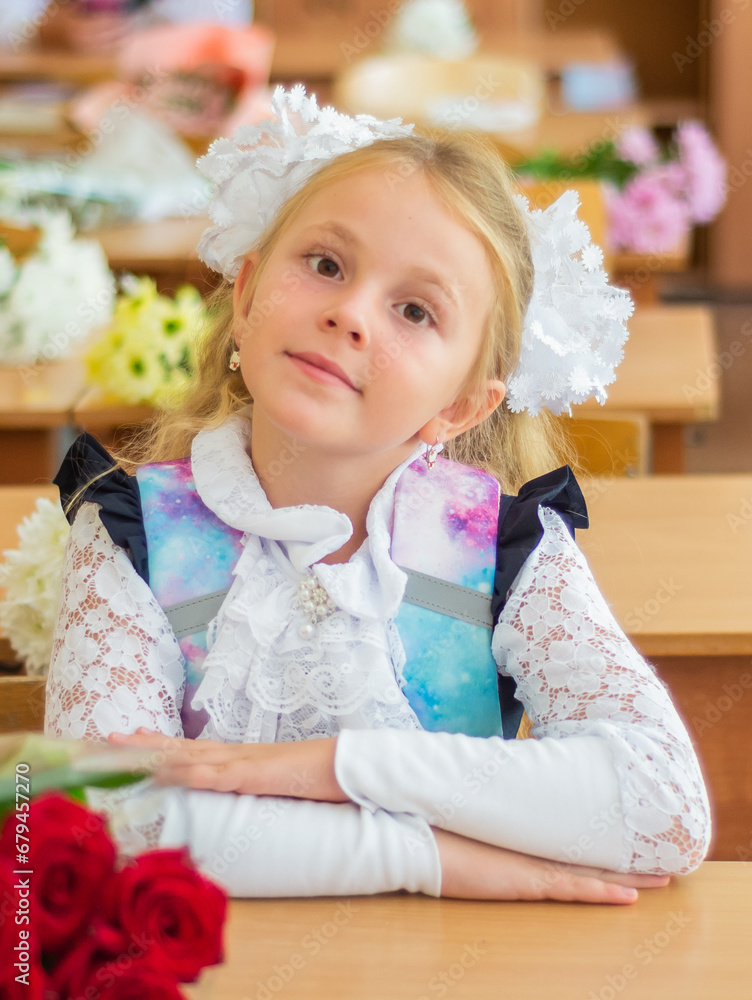 The first time in the first class! A first-grader girl in a beautiful ...