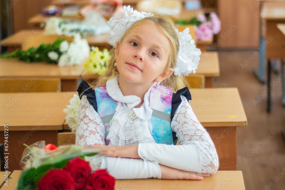 Foto de The first time in the first class! A first-grader girl in a ...