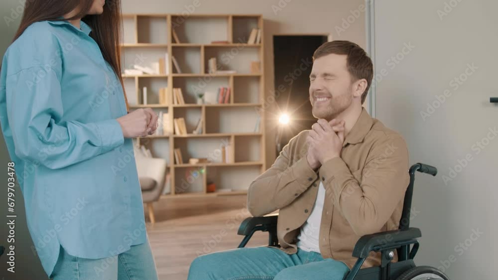 A young woman and a disabled man in a wheelchair are talking, a female ...