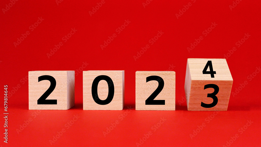 Wooden cubes with numbers 2023 and 2024 on a red background. Symbol of ...