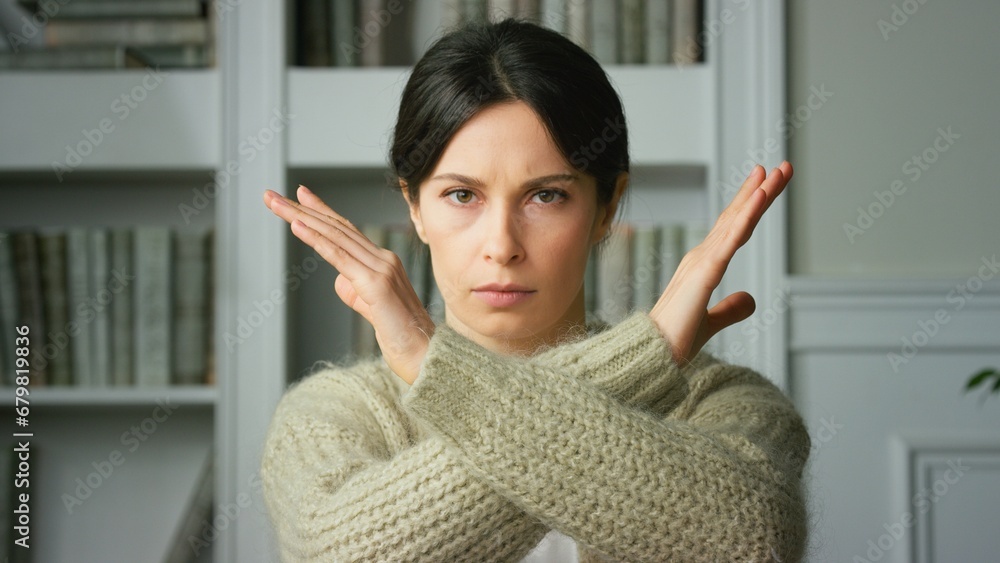 Portrait of young brunette woman showing forbidden sign, crossing her ...