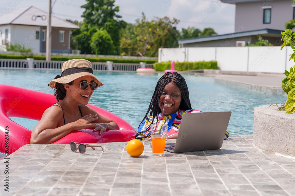 Beautiful African and Hispanic girls Using a laptop computer Video chat ...