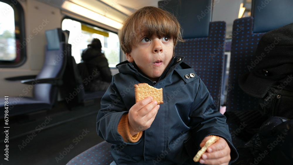 Child snacking butter biscuit while traveling by train. Little boy ...