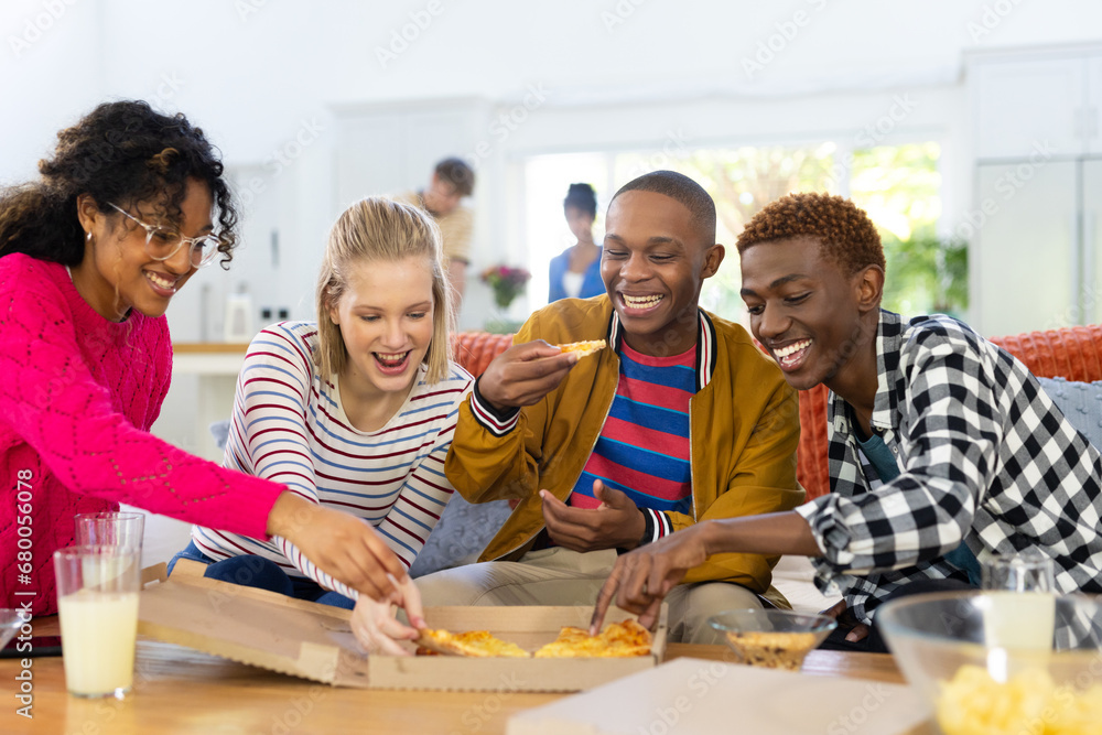 Happy diverse group of teenage friends with snacks and drinks eating ...