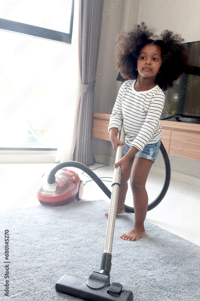 Cute little African girl child with black curly hair vacuuming the ...