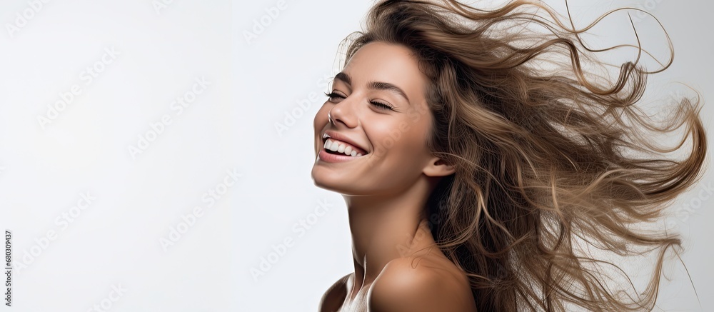 The young woman, with a happy smile on her beautiful face, poses ...