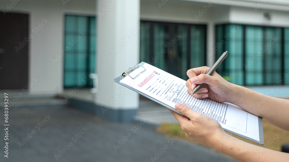 Foreman's hand is using a pen checking on building inspection report ...