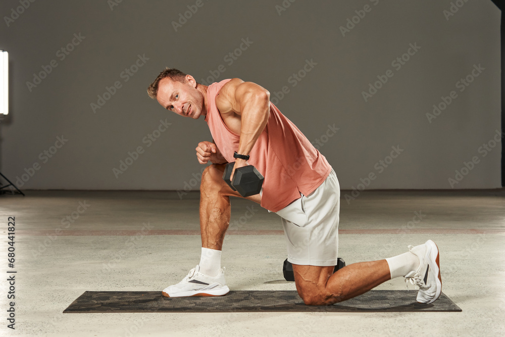 leg-supported lunge and one-arm dumbbell row by Caucasian athlete ...