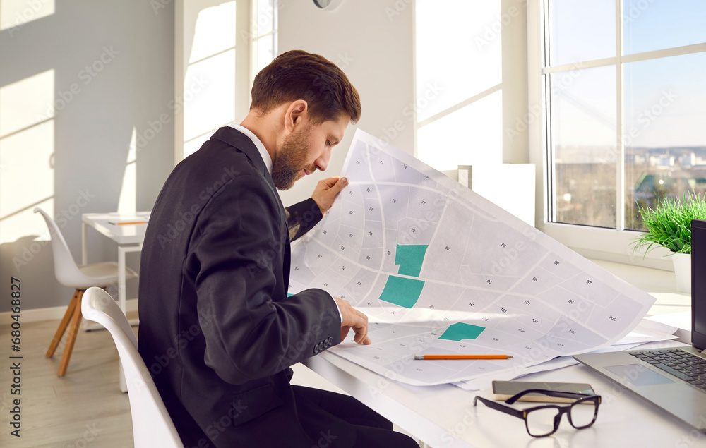 Side view portrait of a professional cartographer working with printed ...