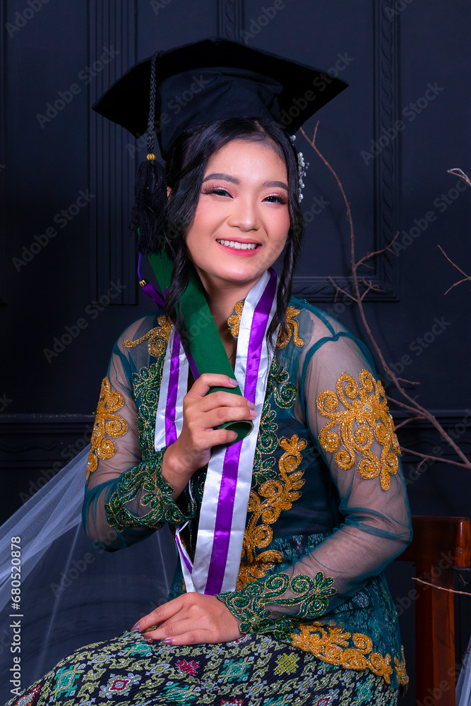 beautiful Asian woman who graduated sitting on a chair smiling sweetly ...