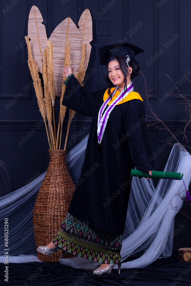 Beautiful mature Asian girl graduating, smiling happily, hands raising ...