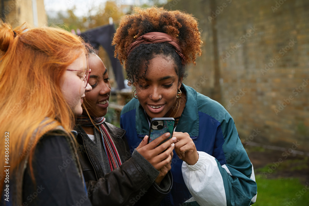 Girl showing her friends something on her phone.Concept of gender ... Girl showing her friends something on her phone.Concept of gender ...