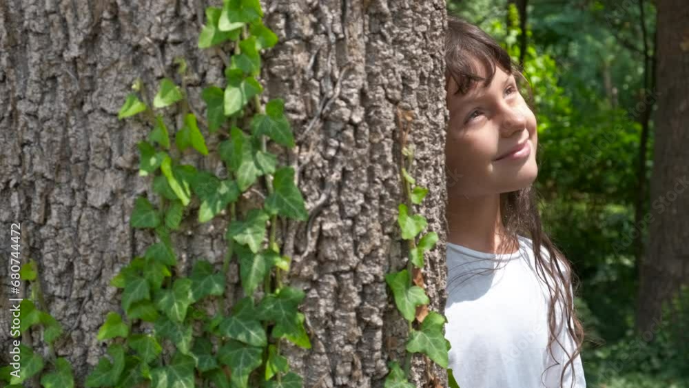 Dreamy child lean by park tree. A pretty little girl lean by the old ...