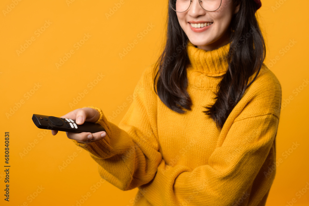 A happy young woman in her 30s, wearing a yellow sweater, sits ...