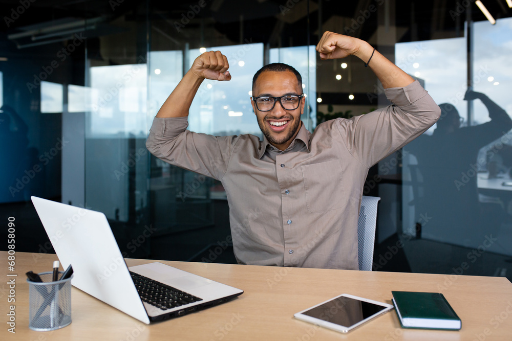 Happy man working in office showing muscles raising arms up, happy at ...