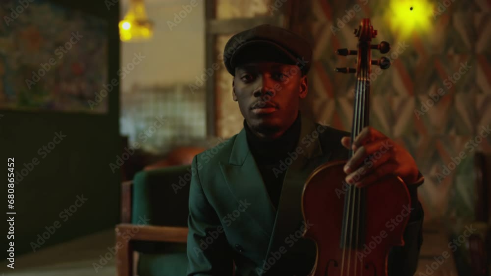 Medium portrait of young Black male jazz musician wearing dark green ...