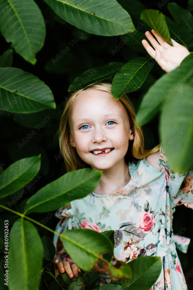 Smiling girl standing under branches of tree Stock Photo | Adobe Stock
