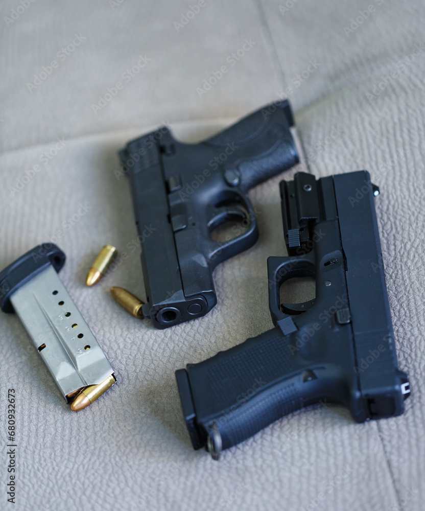 Two pistols with magazine loaded with 9mm bullets on a grey background ...