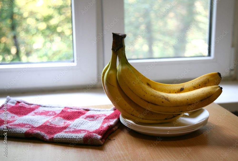 A bunch of bananas lying on a solid kitchen table. Sweet ripe bananas ...