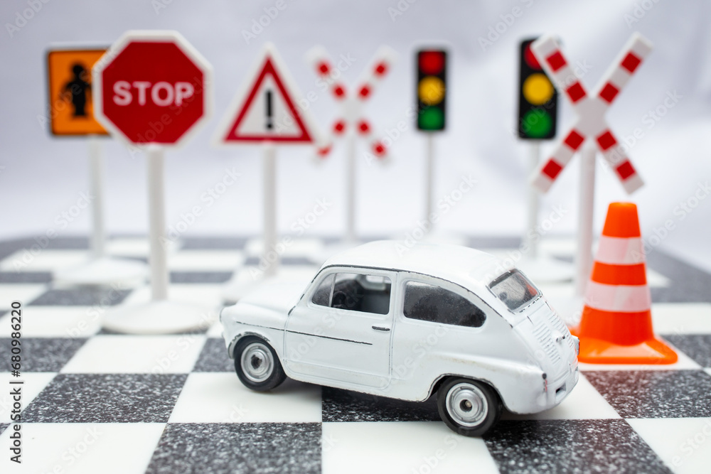 white little model car with traffic signs on a chess board, driving ...