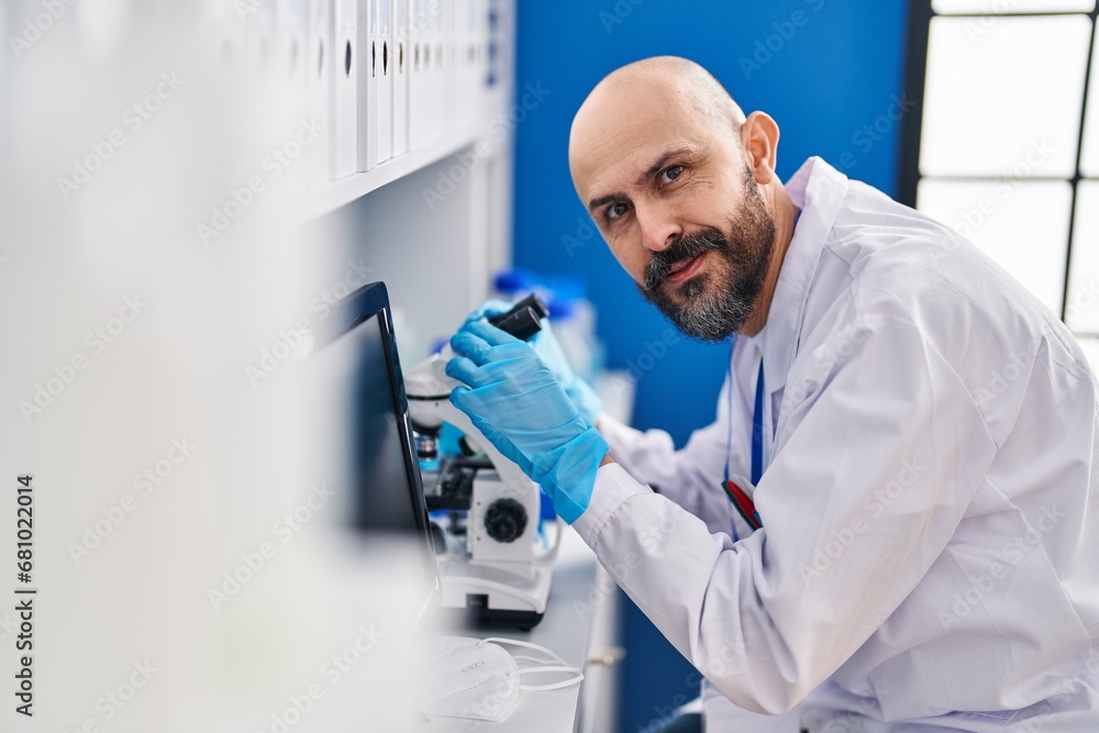 Young bald man scientist using microscope at laboratory Stock Photo ...