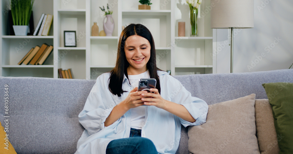 Smiling attractive woman checking social media app playing game ...